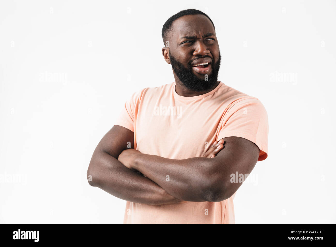 Portrait of a confused african man wearing t-shirt standing isolated ...