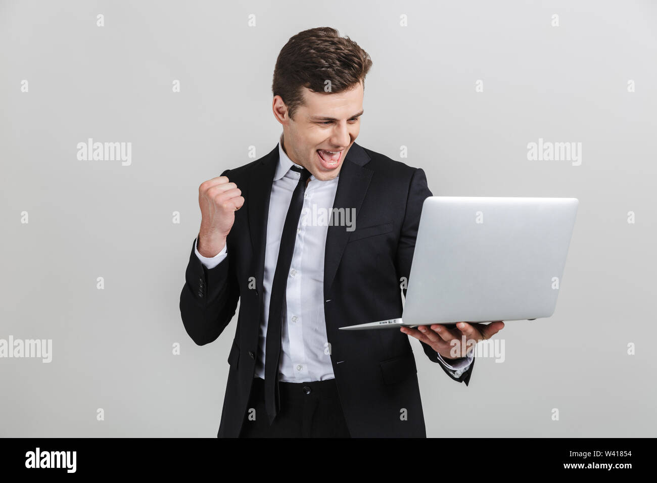 Image of cheerful excited businessman in formal suit celebrating ...