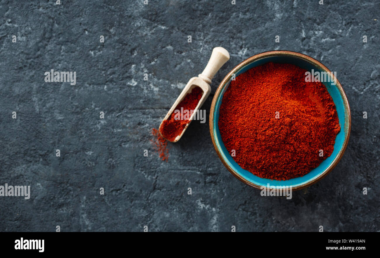 Chili pepper powder on dark stone background with free space for text ...