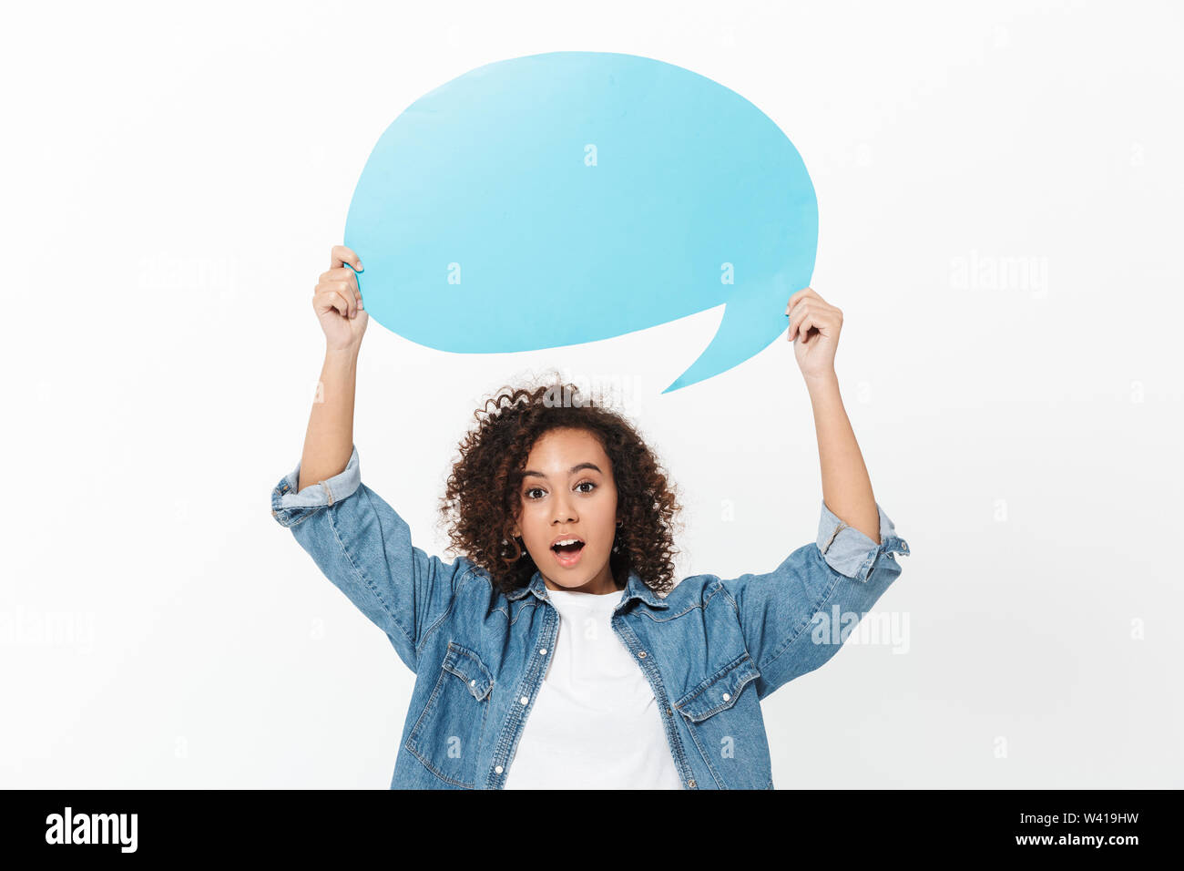 Portrait of a pretty confused casual african girl standing isolated ...