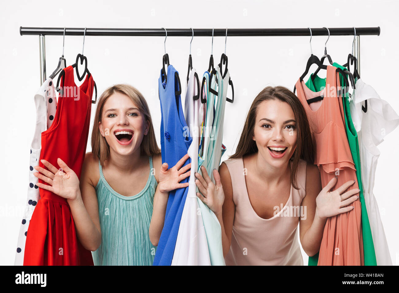 Two cheerful pretty young girls isolated over white background ...