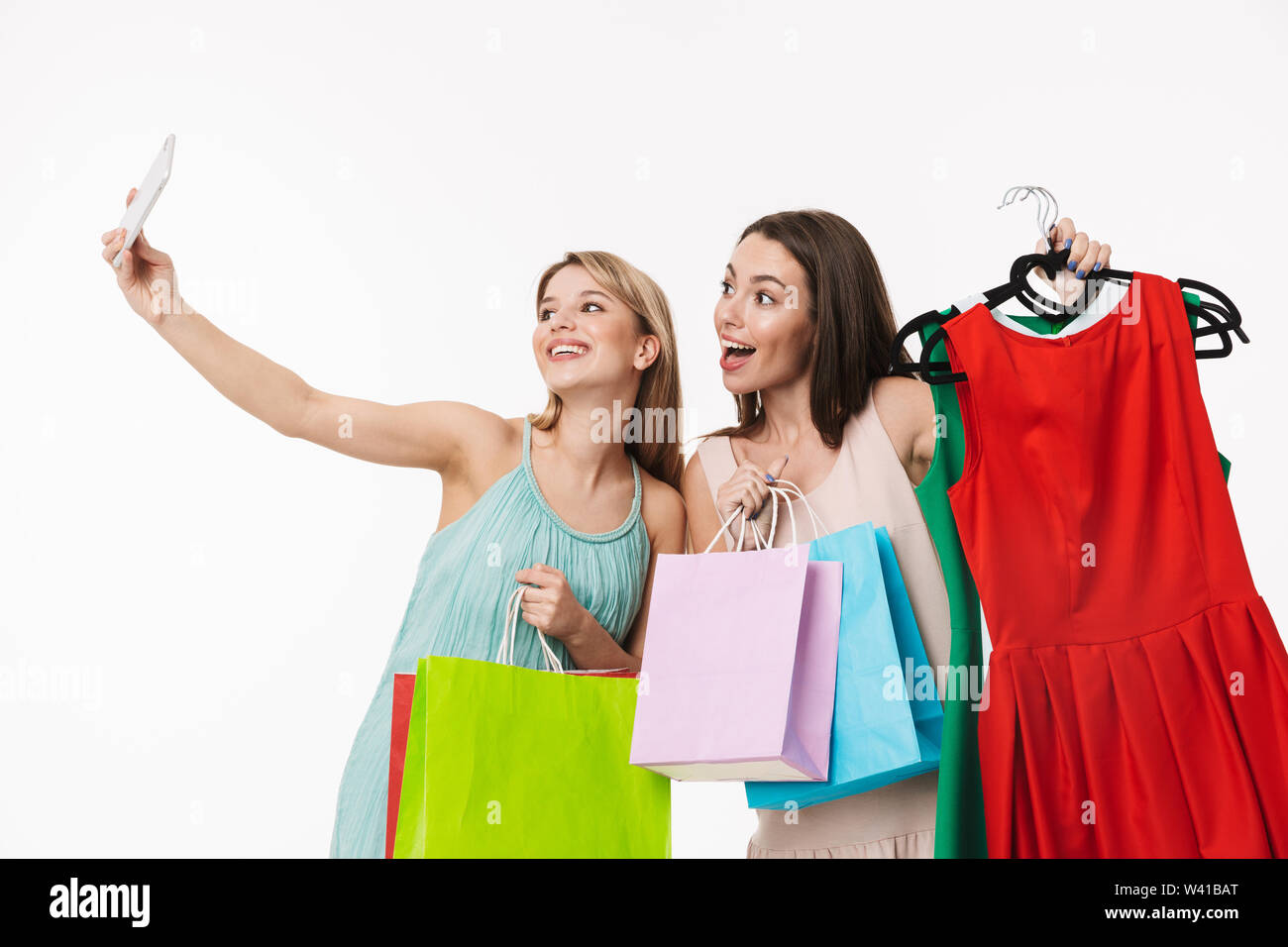 Two cheerful pretty young girls isolated over white background ...
