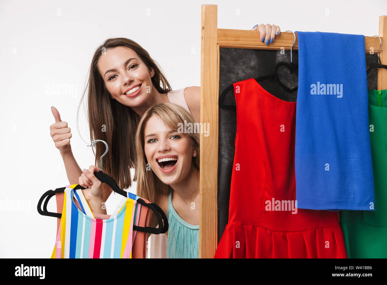 Two cheerful pretty young girls isolated over white background ...