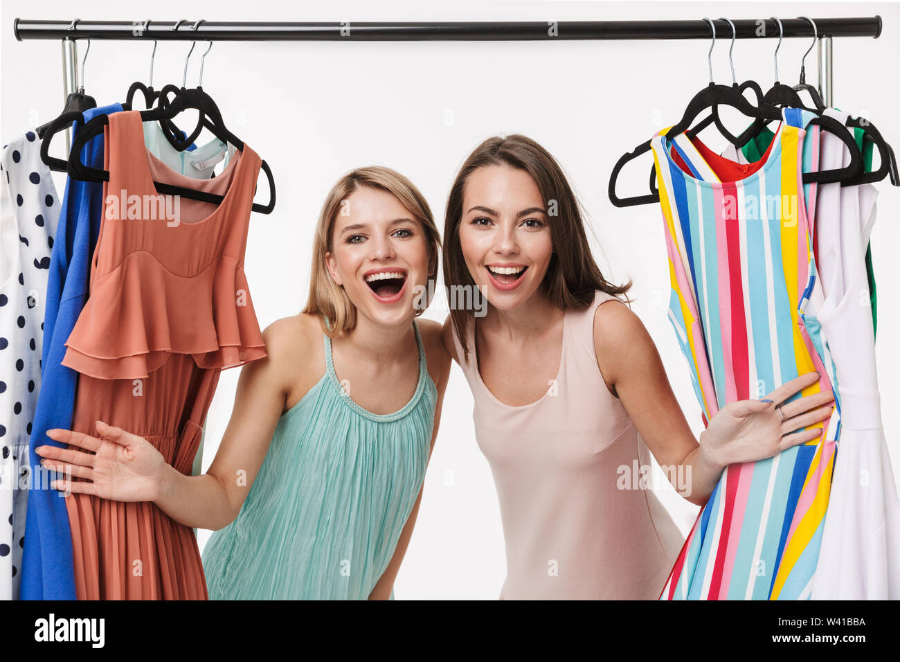 Two cheerful pretty young girls isolated over white background ...