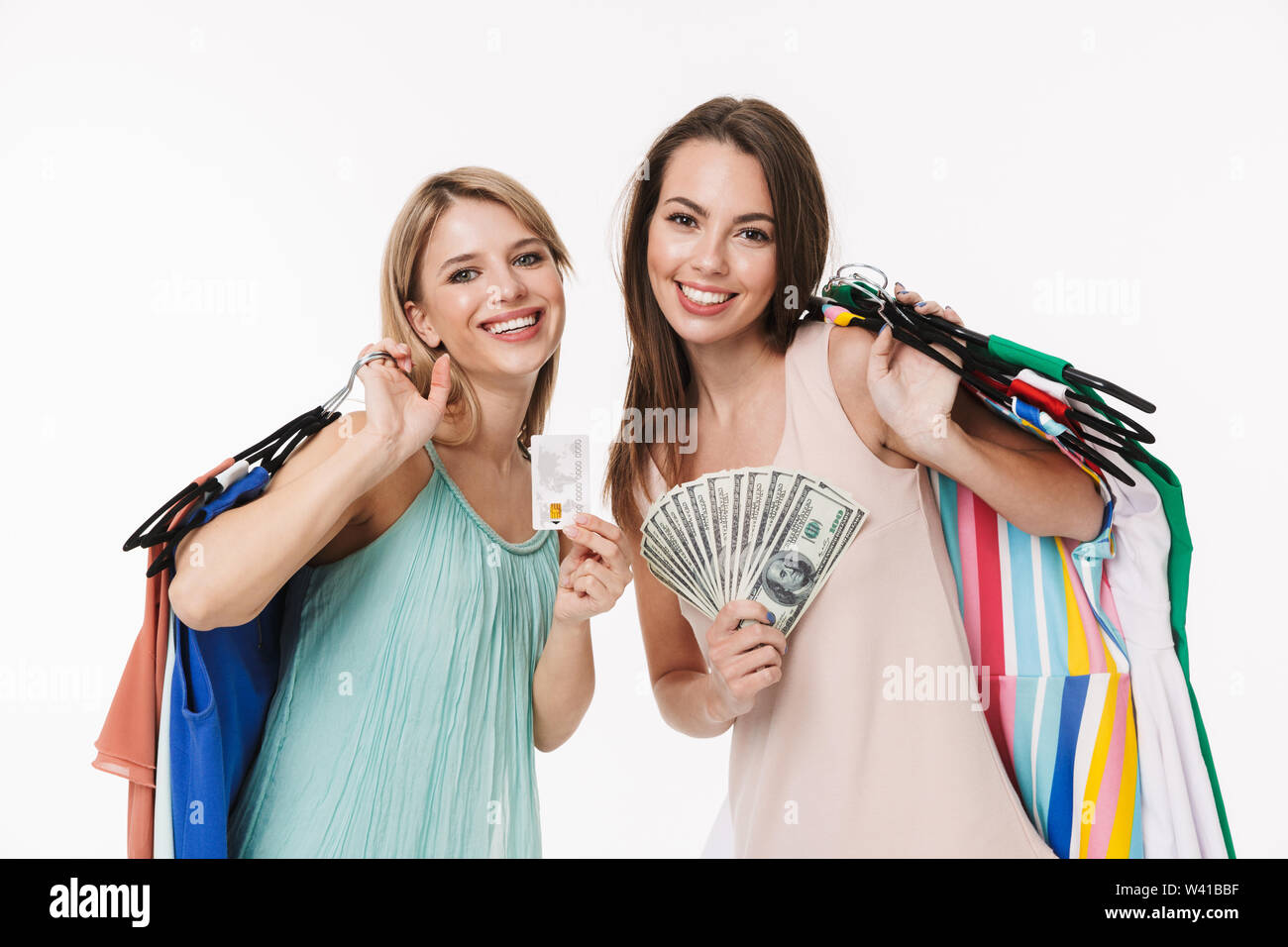Two cheerful pretty young girls isolated over white background ...
