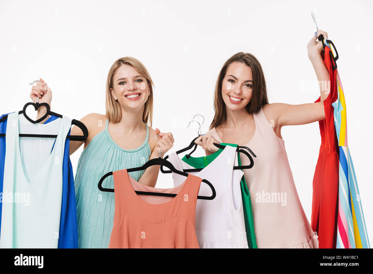 Two cheerful pretty young girls isolated over white background ...