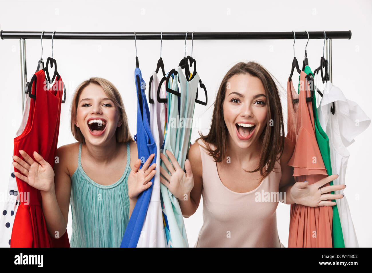 Two cheerful pretty young girls isolated over white background ...