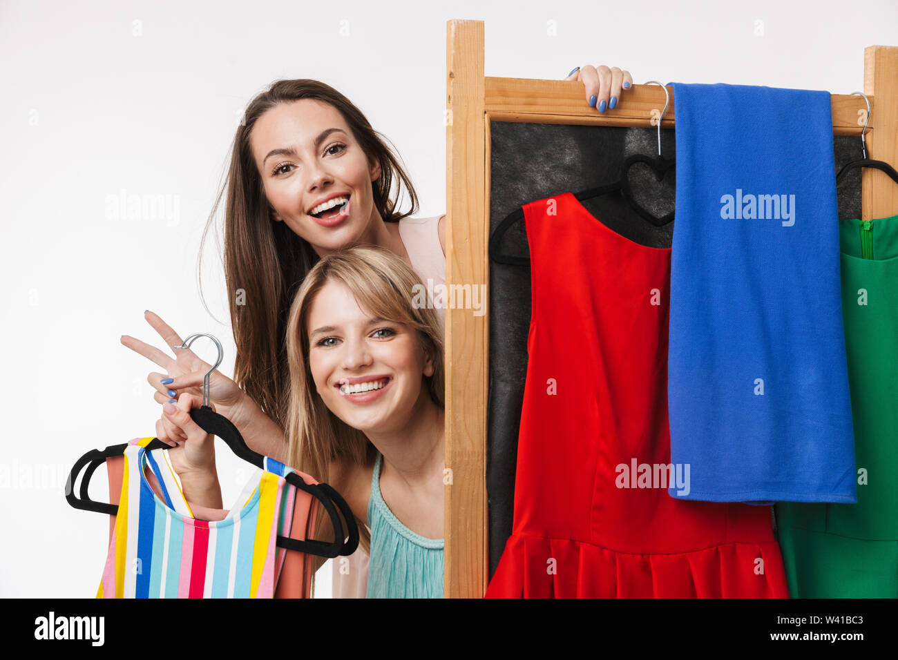 Two cheerful pretty young girls isolated over white background ...