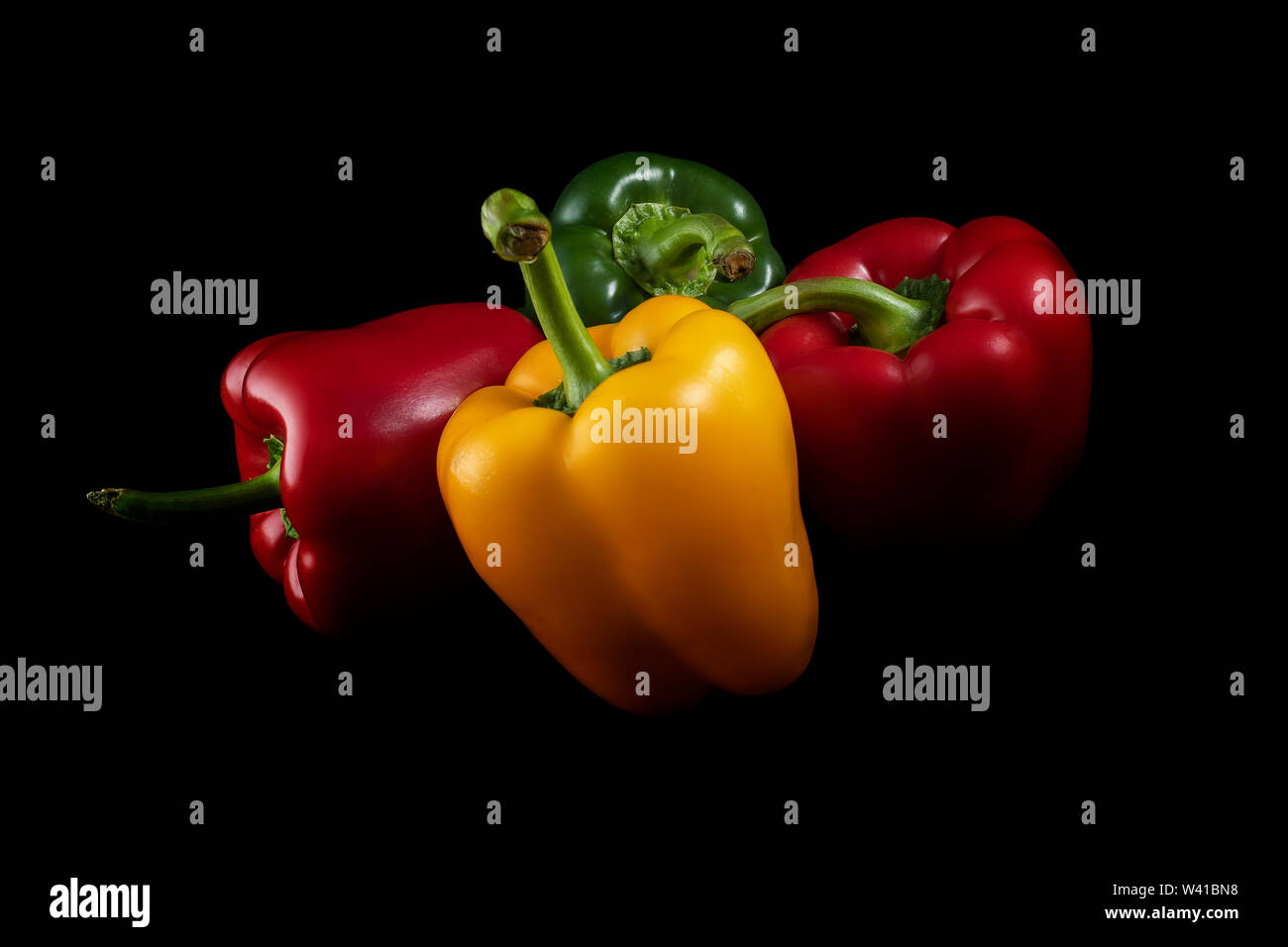 Three, sweet colorful peppers on a black background. Three colors of ...