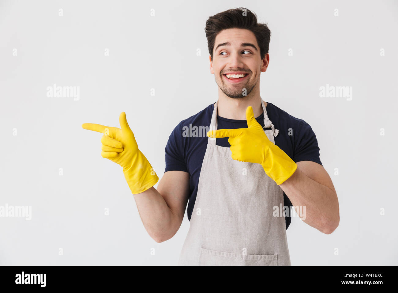Photo of optimistic young man wearing yellow rubber gloves for hands ...