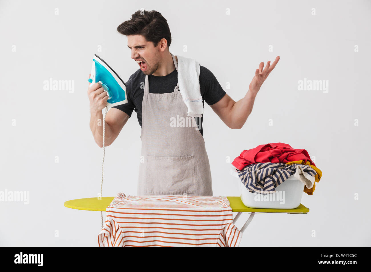 Image of a young angry houseman househusband screaming on iron near ...