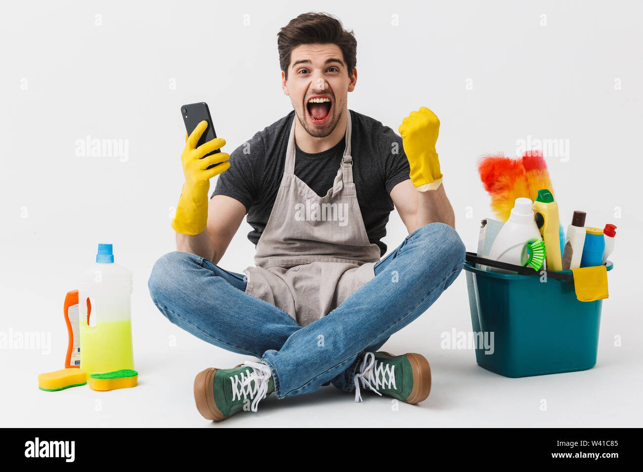 Image of a happy excited young houseman househusband with cleansers on ...