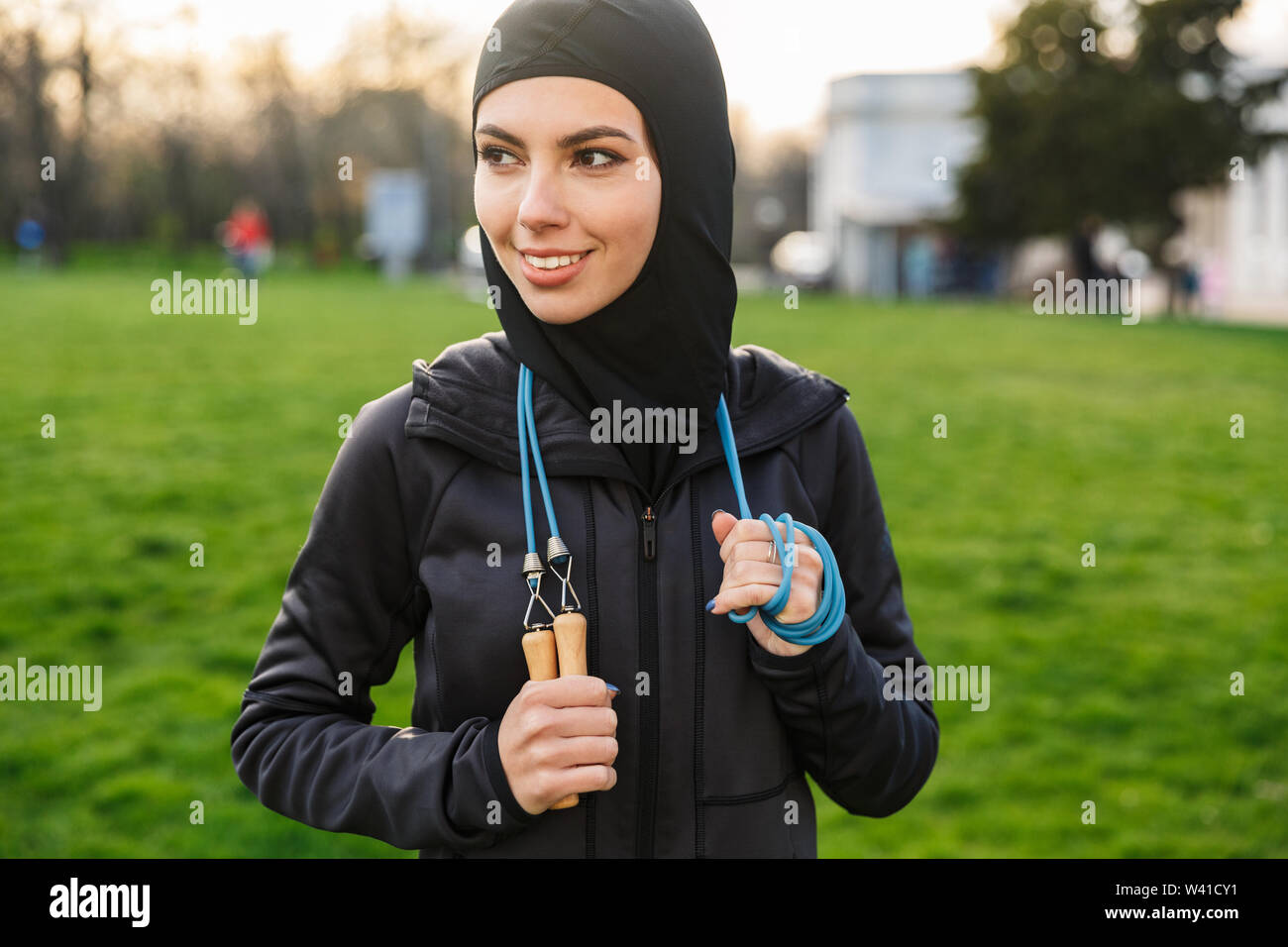 Image of a young cheerful happy muslim sports fitness woman dressed in ...