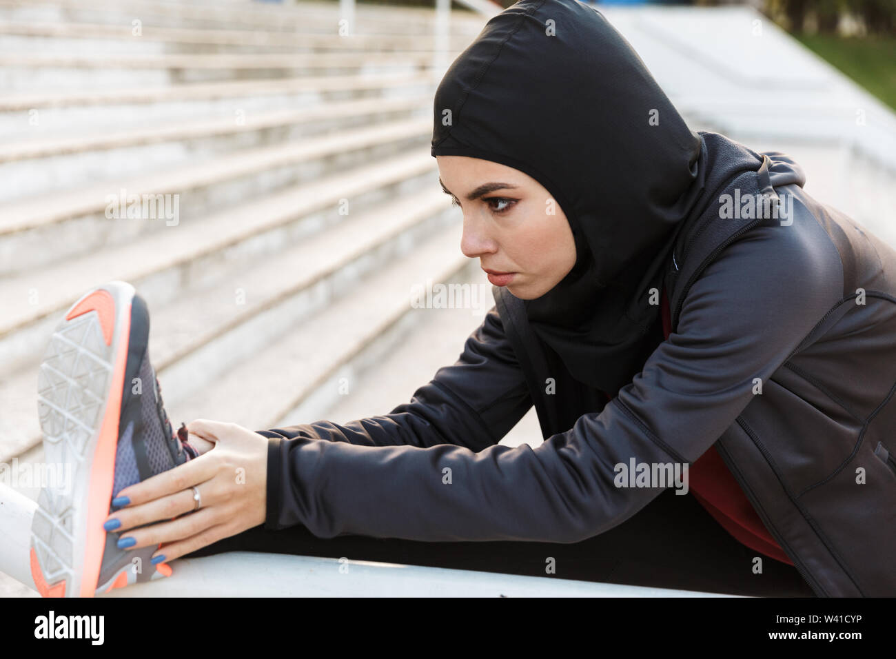 Image of a young concentrated muslim sports fitness woman dressed in ...