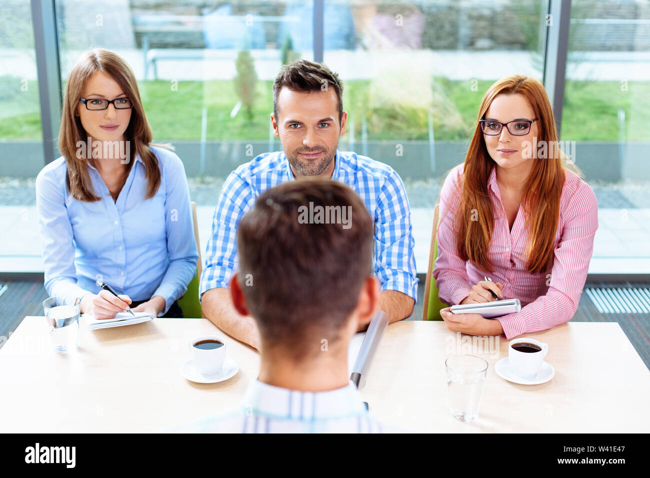 Interview. Three corporate people Interview young man Stock Photo - Alamy