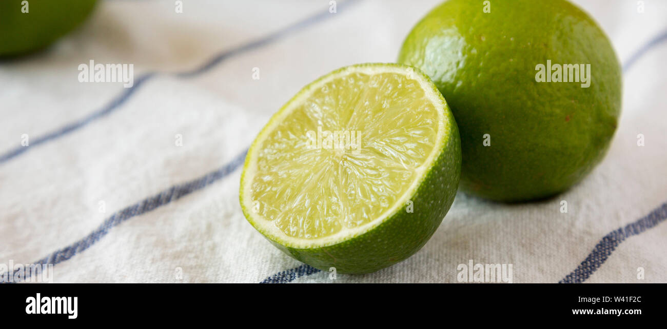 Whole and cut green citrus limes on cloth, side view. Close-up Stock ...