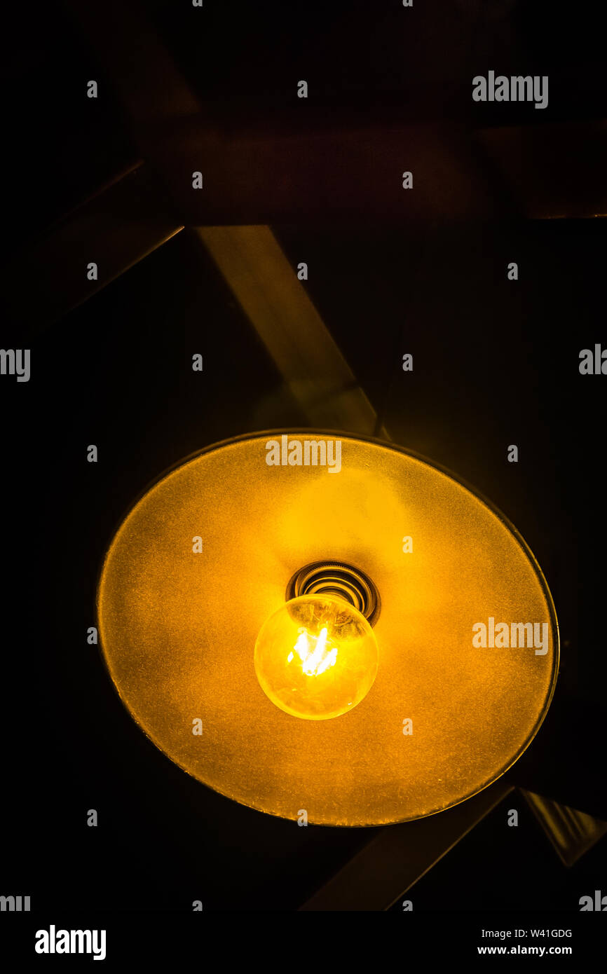 Lighted Incandescent bulb with round reflector against a dark ...