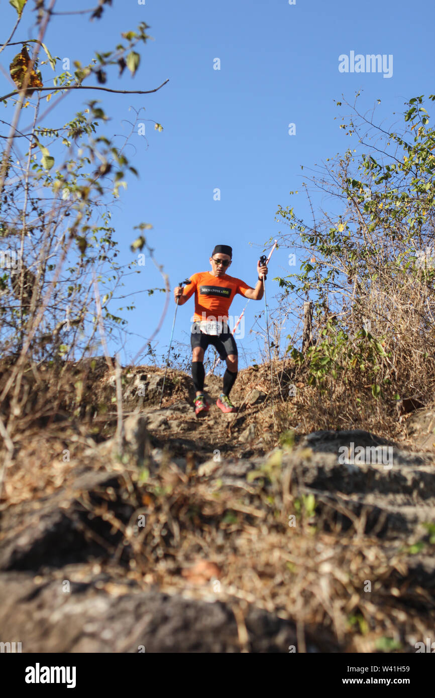 A man traces a path through a barren, steep forest with a tracking ...
