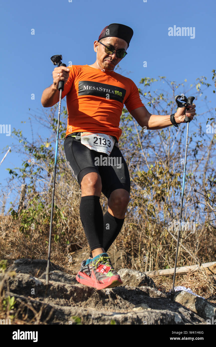 A man traces a path through a barren, steep forest with a tracking ...