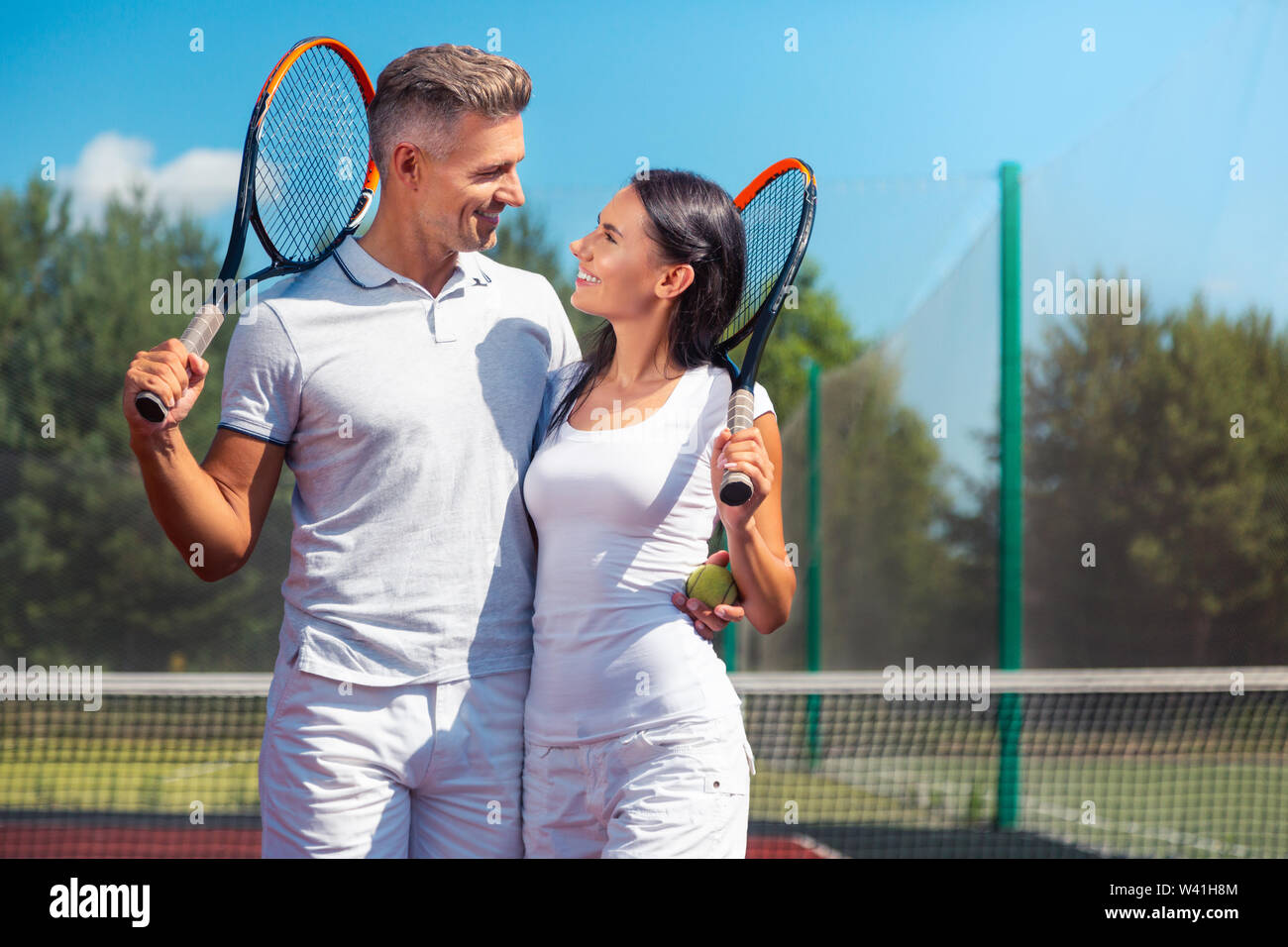 Couple Outdoors Holding Tennis Rackets High Resolution Stock ...