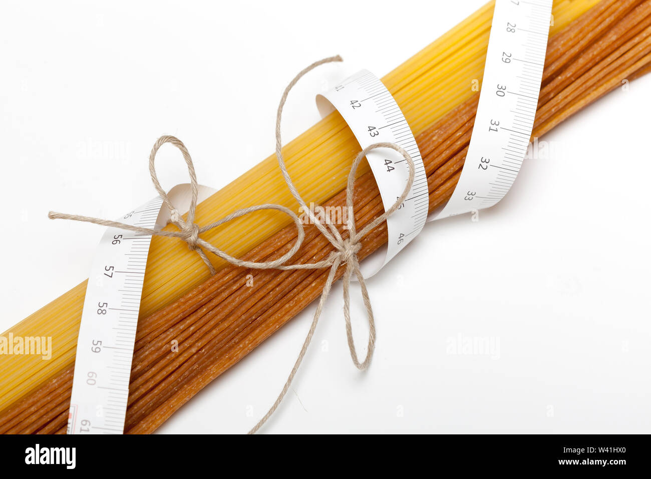 spaghetti bundle of wrapped in tape measure on a white background Stock ...