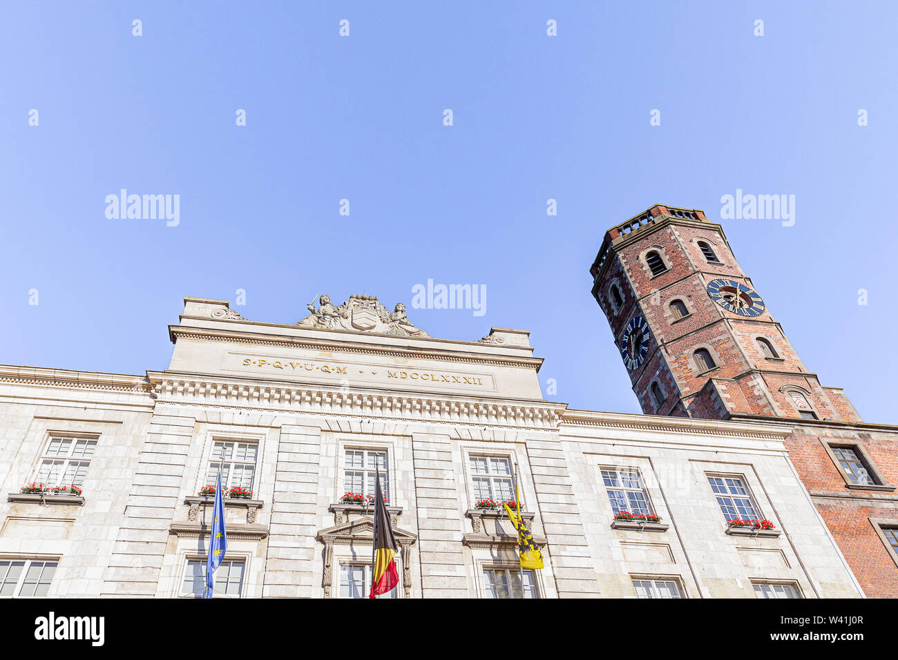 The City of Menen town hall and belfry with blue sky, Flanders, Belgium ...