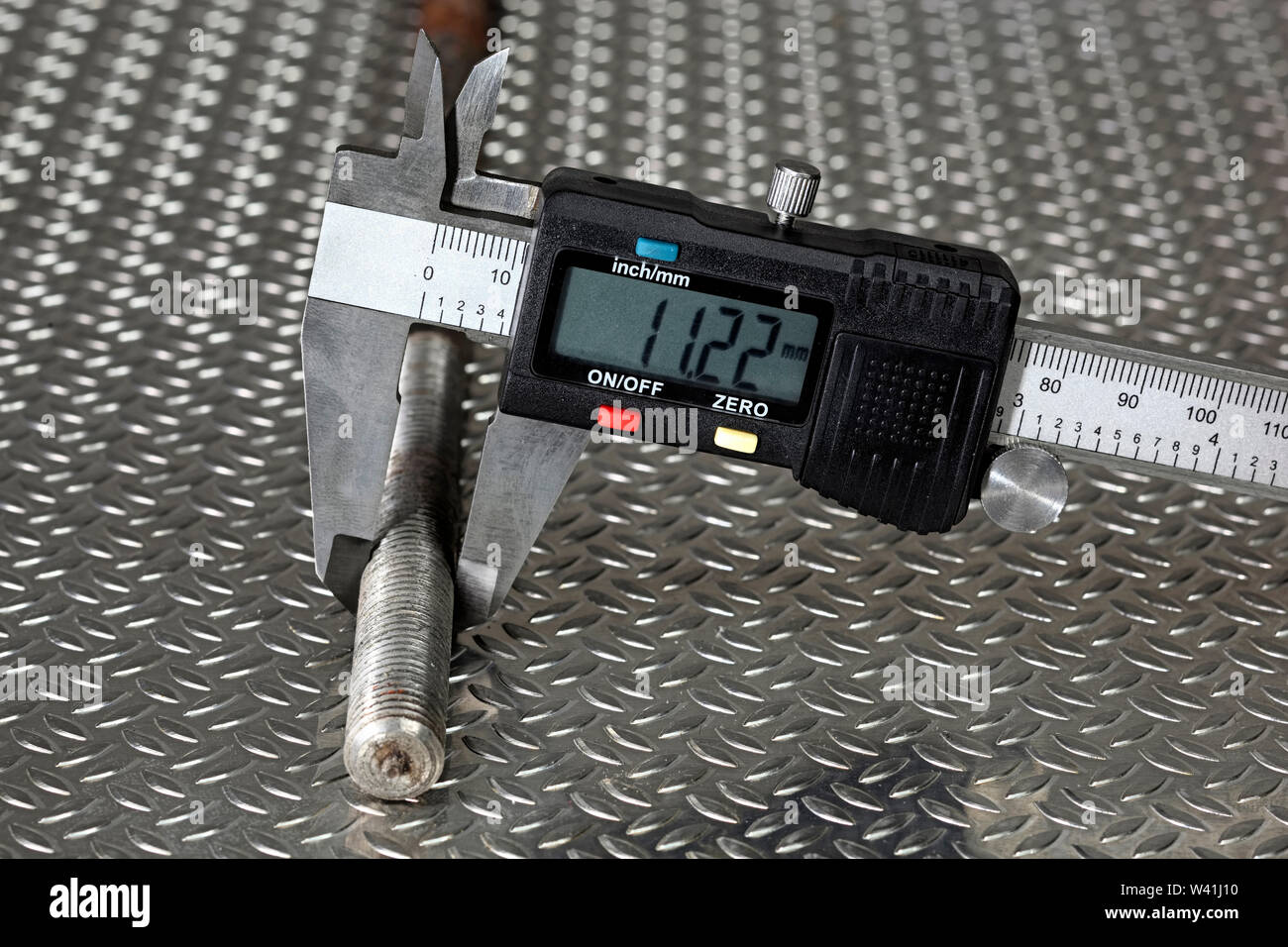 Measurement of a threaded steel rod with digital caliper over ...