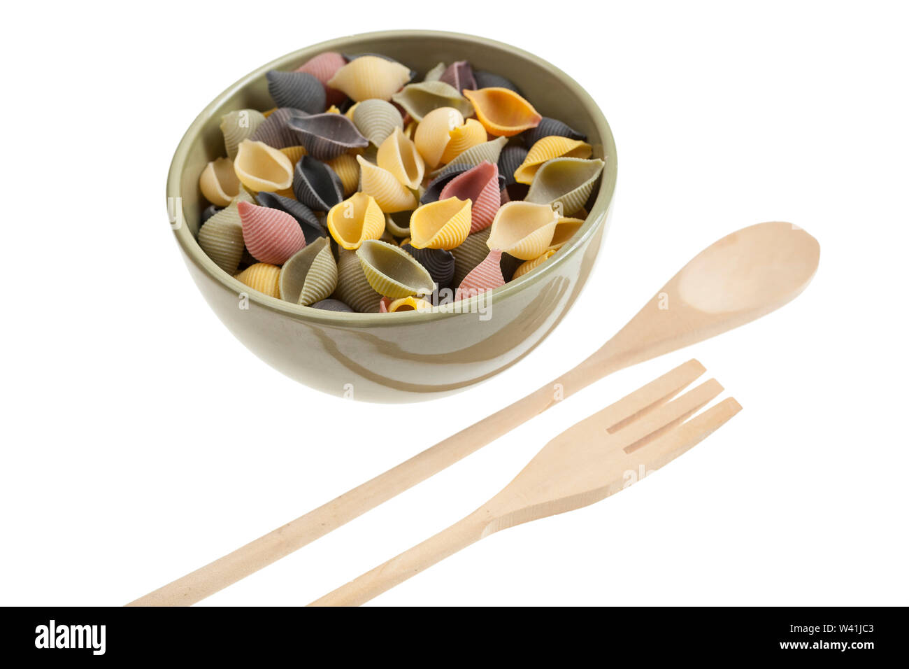 Cup with five color shell pasta and wooden spoоn and fork isolated on ...