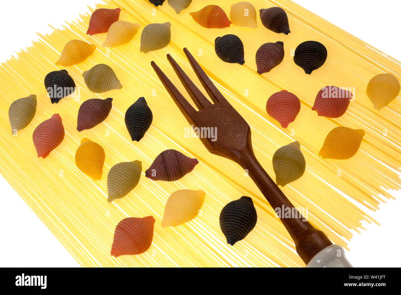 Five color shell pasta over spaghetti and wooden fork, isolated on ...