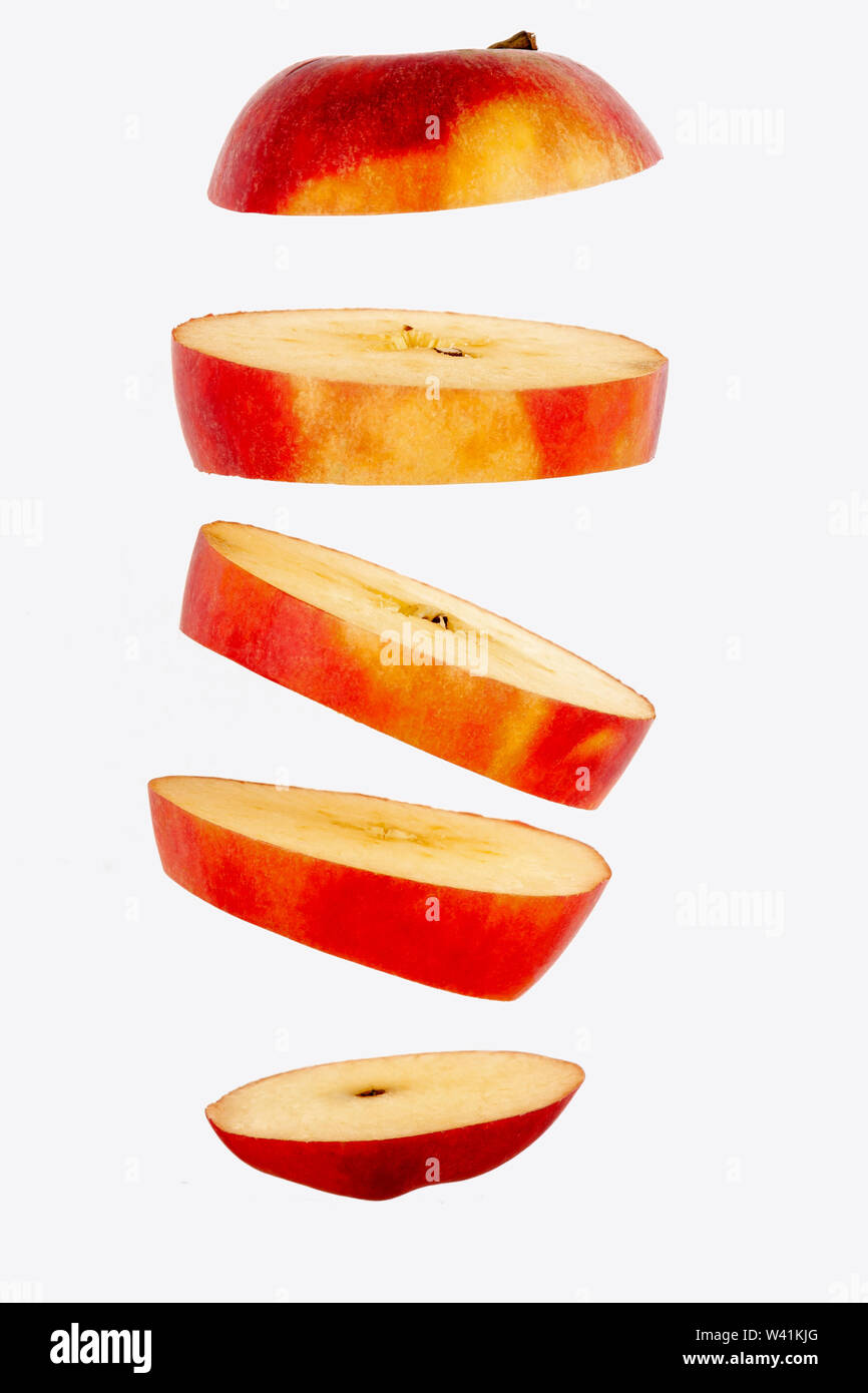 The moment of falling of the cut apple on a white background is fixed ...
