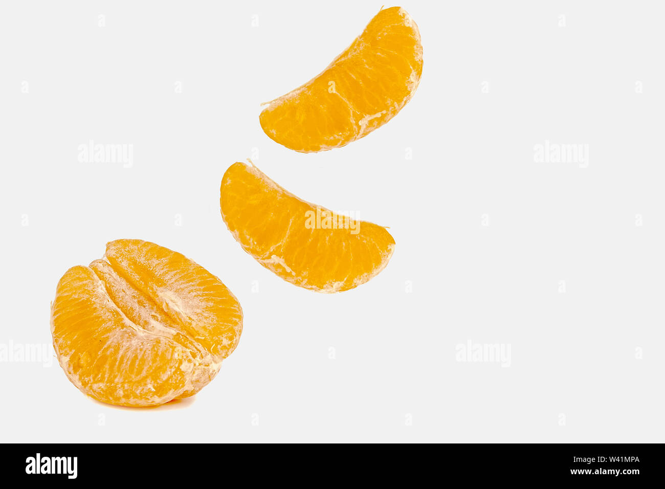 Falling mandarin slices on a white background Stock Photo - Alamy