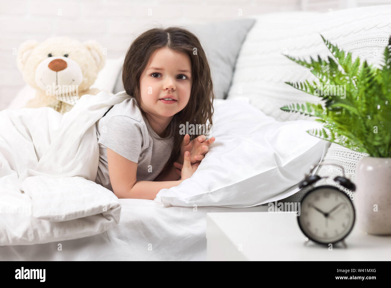 cute little child girl wakes up from sleep in bed in the morning Stock ...