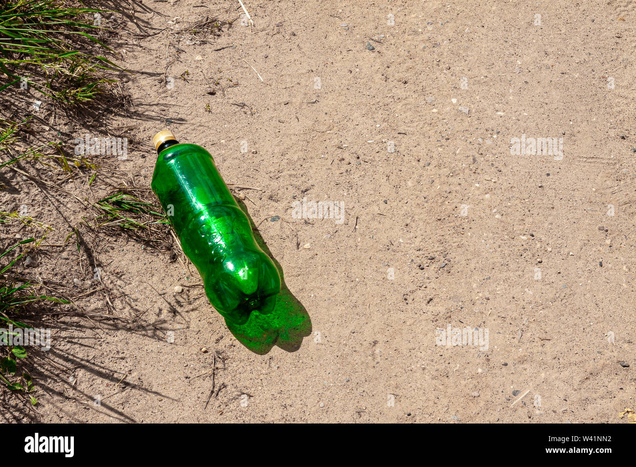 Empty plastic bottle lying on the ground Stock Photo - Alamy