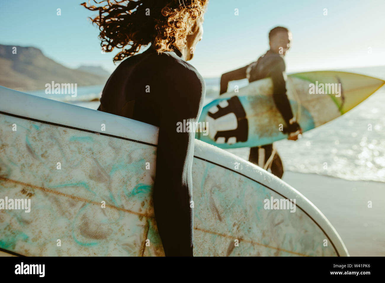 Two young men with surfboard going for surfing in the sea. Surfers ...
