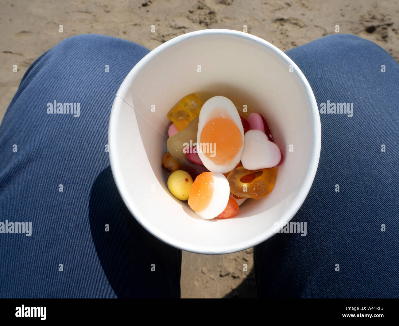 Pick n mix in a cup on the beach Stock Photo - Alamy