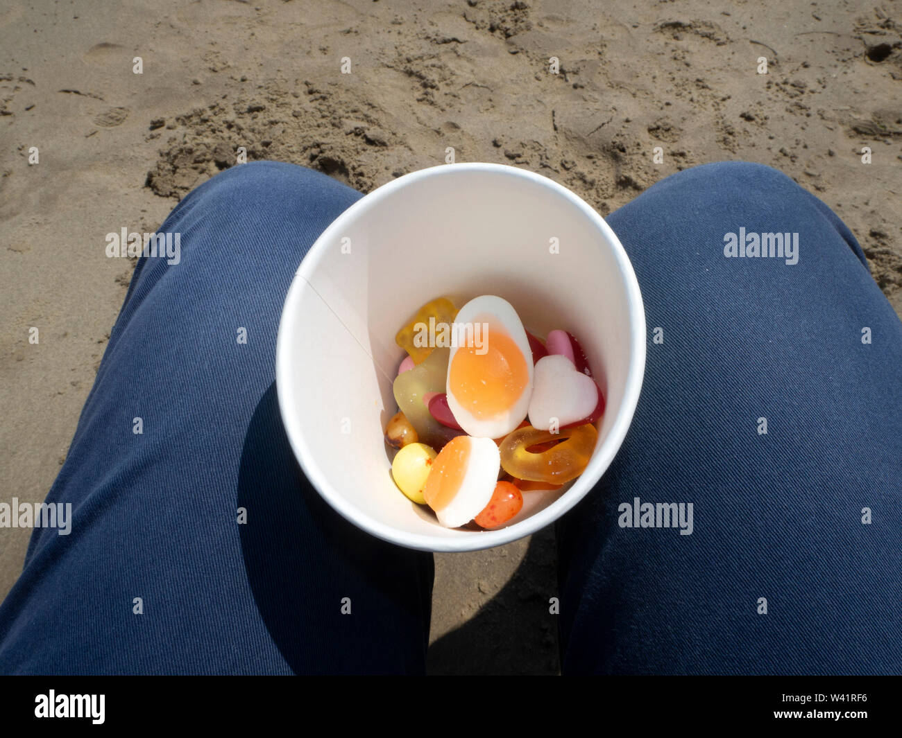 Pick n mix in a cup on the beach Stock Photo - Alamy