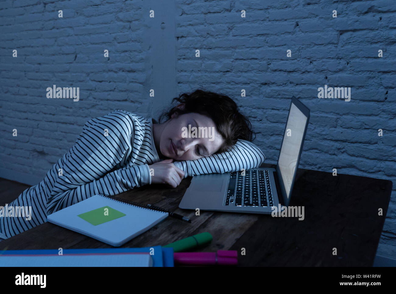 Overworked and tired female student asleep on the desk while working ...
