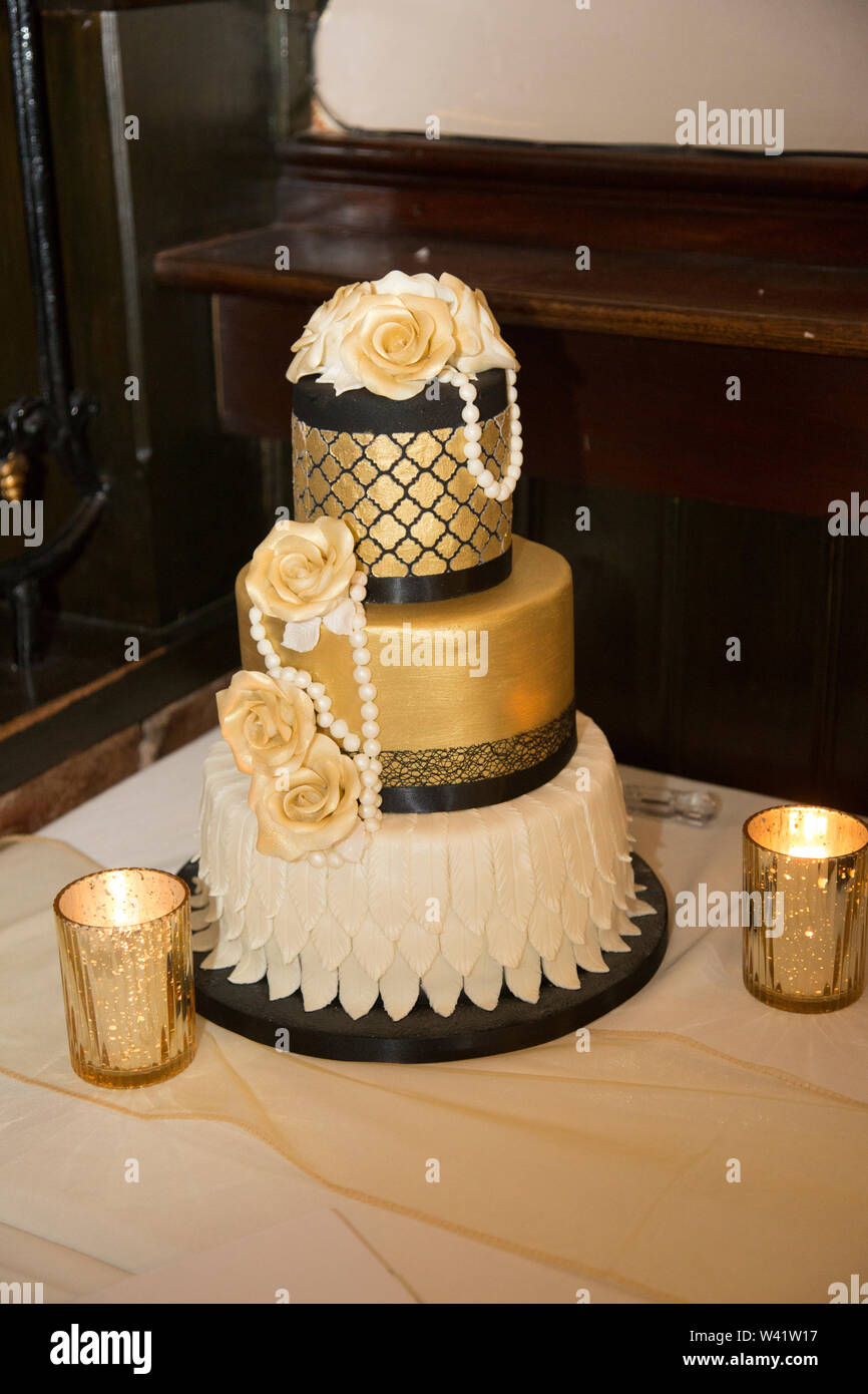 Highly decorated, gold three tier wedding cake, gold icing sugar with ...