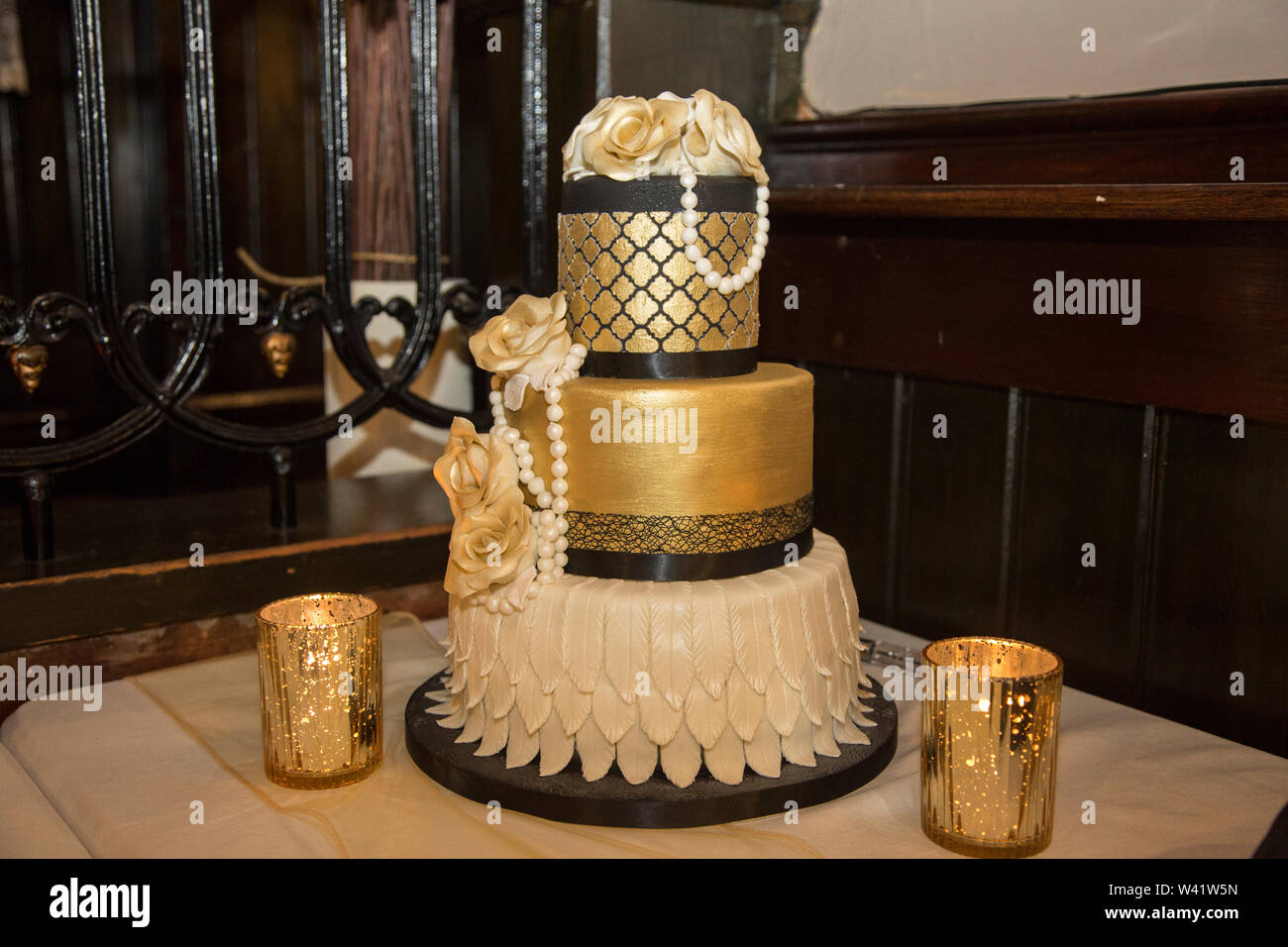 Highly decorated, gold three tier wedding cake, gold icing sugar with ...