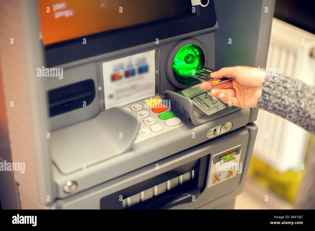 Finance, money, bank and people concept - close up of hand entering pin ...