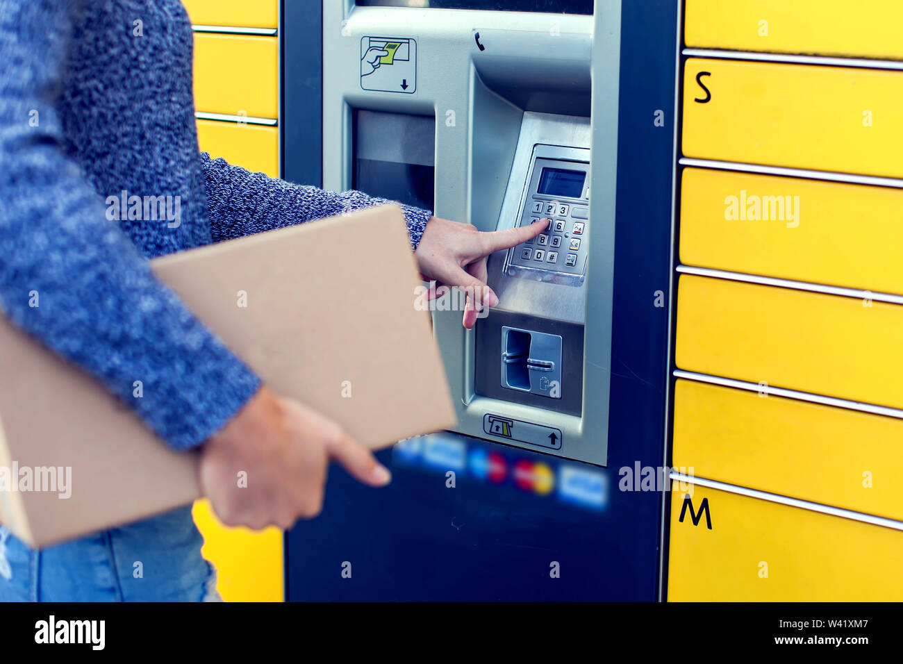 Woman client using automated self service post terminal machine or ...