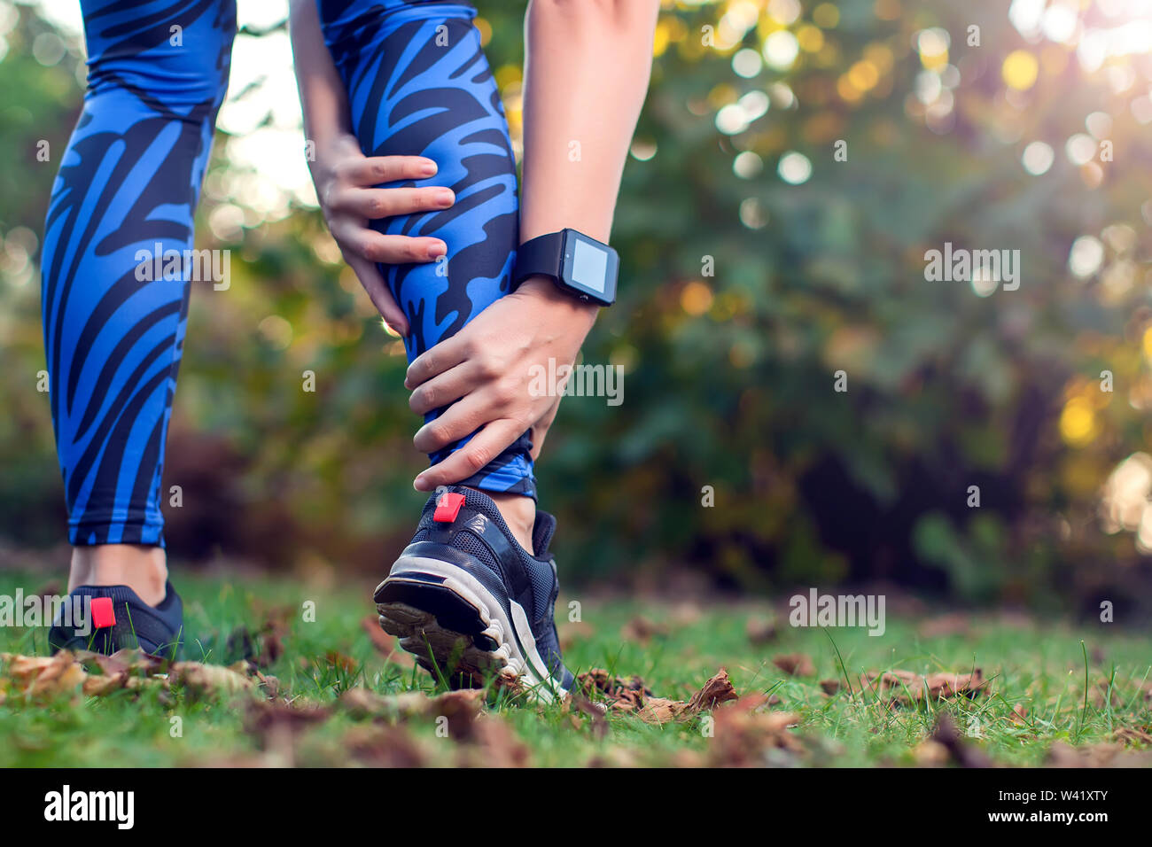 Woman runner hold her sports injured leg outdoor. Sport, medicine and ...