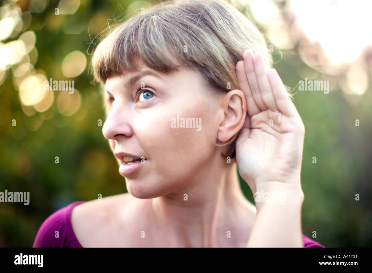 Listening.Close up on hand and ear listening for a quiet sound or ...
