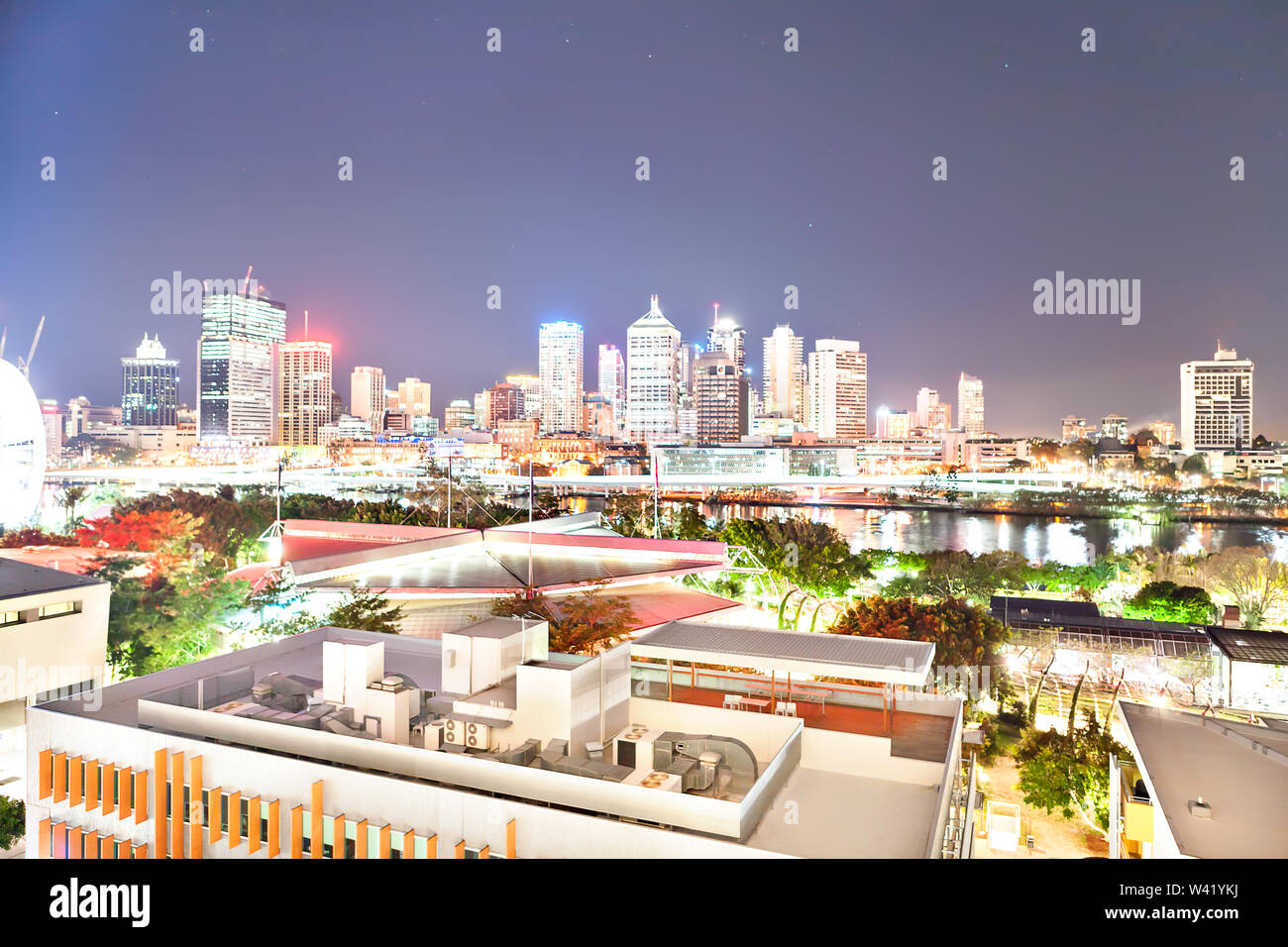 Brisbane City at night and the view over the buildings showing tress ...