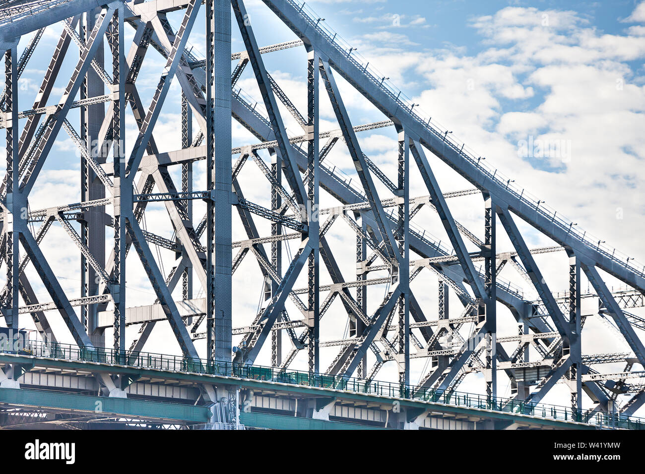 Closeup of a huge metal bridge showing steel beams and pillars under ...