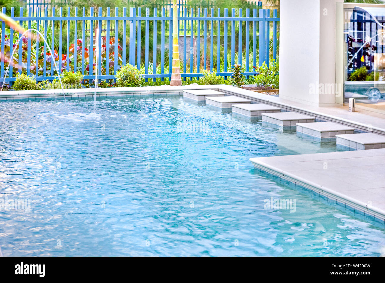 Luxury home entrance, colorful water in swimming pool near luxury house ...