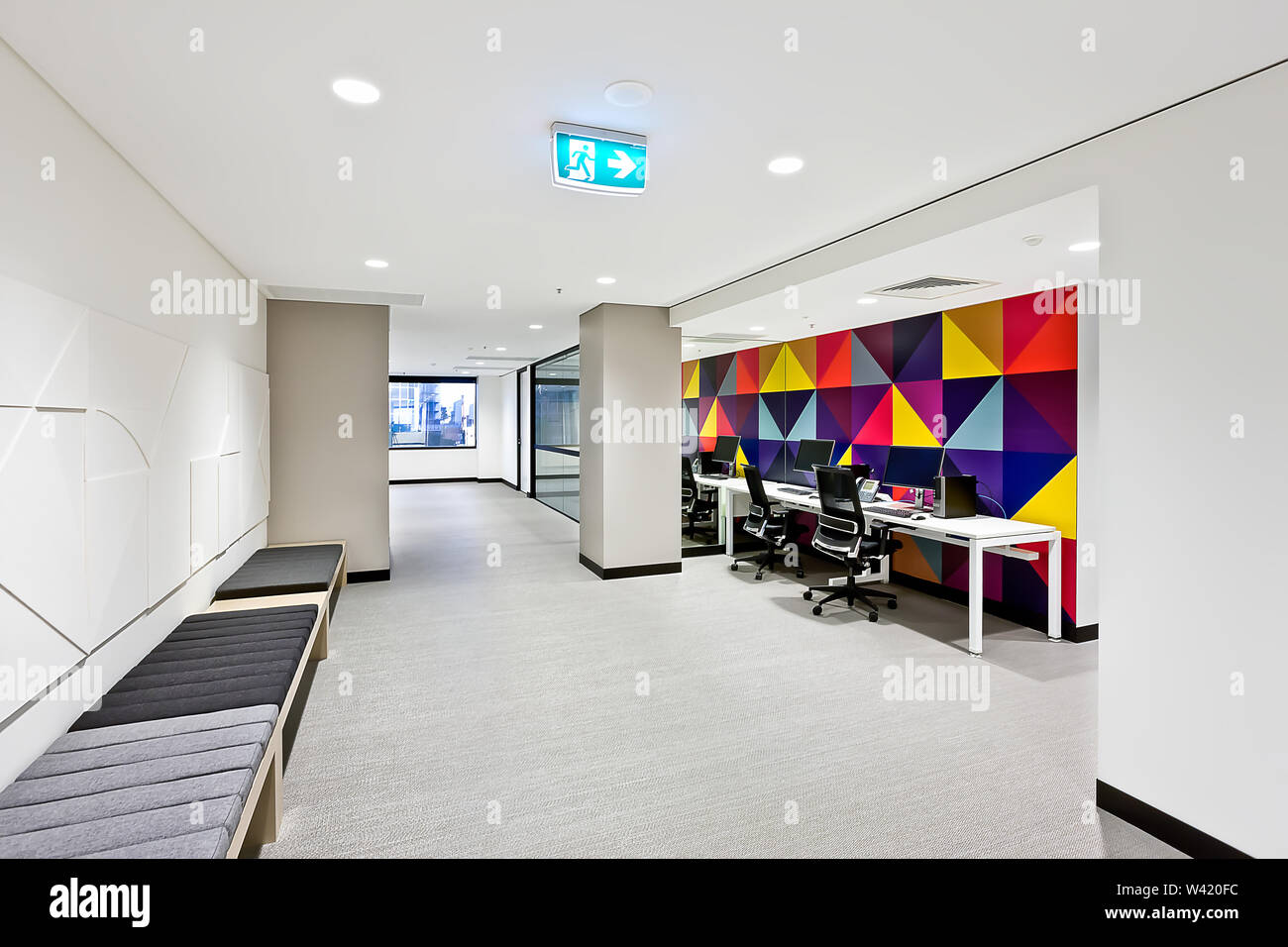 Modern and long computer hall with cushion benches and chairs next ...