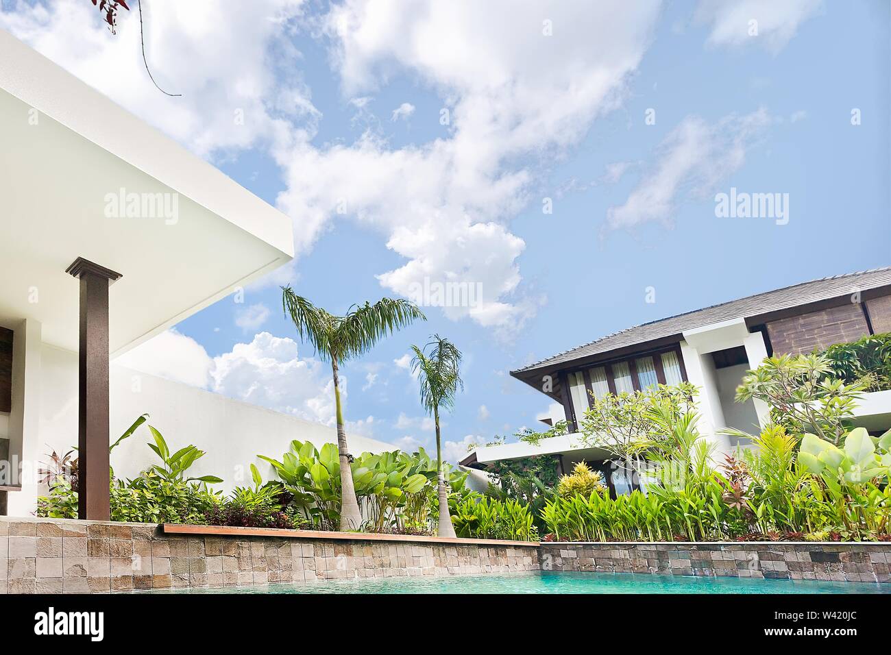 Swimming pool closeup with a luxury hotel view and fancy plants around ...