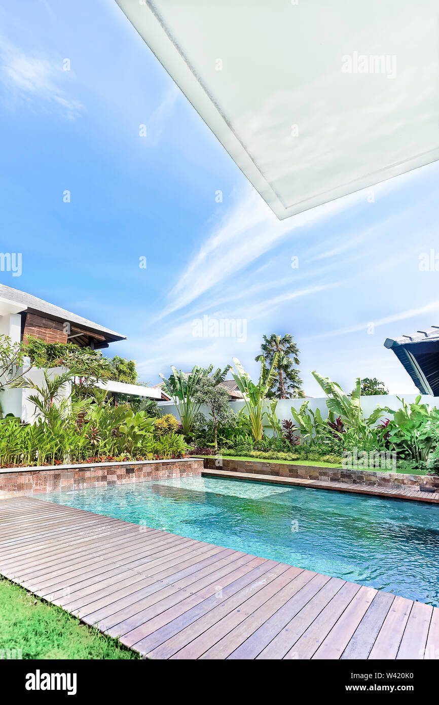 Looking through the wooden path to the swimming pool is covered with ...