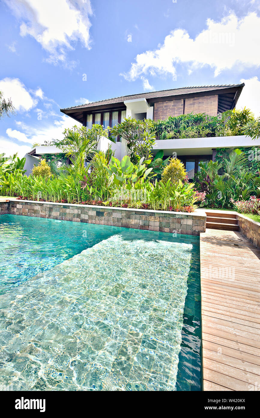 Modern swimming pool with ornamental plants at a modern hotel garden ...